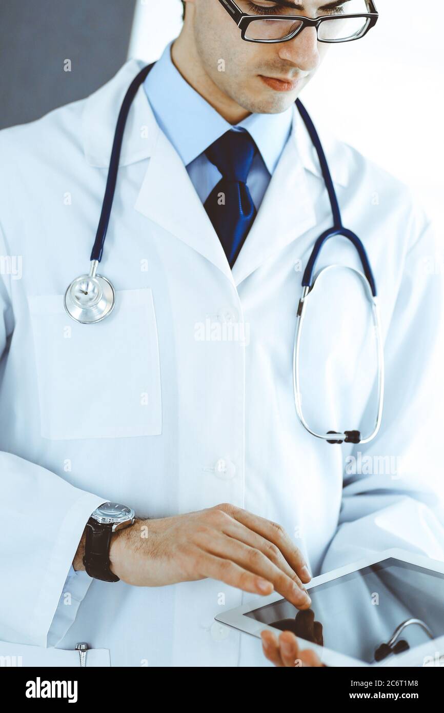 Doctor man using tablet computer for network research or virtual ...