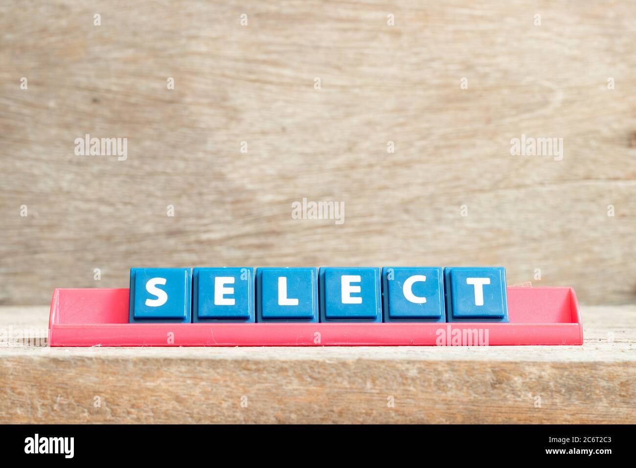 Tile letter on red rack in word select on wood background Stock Photo ...