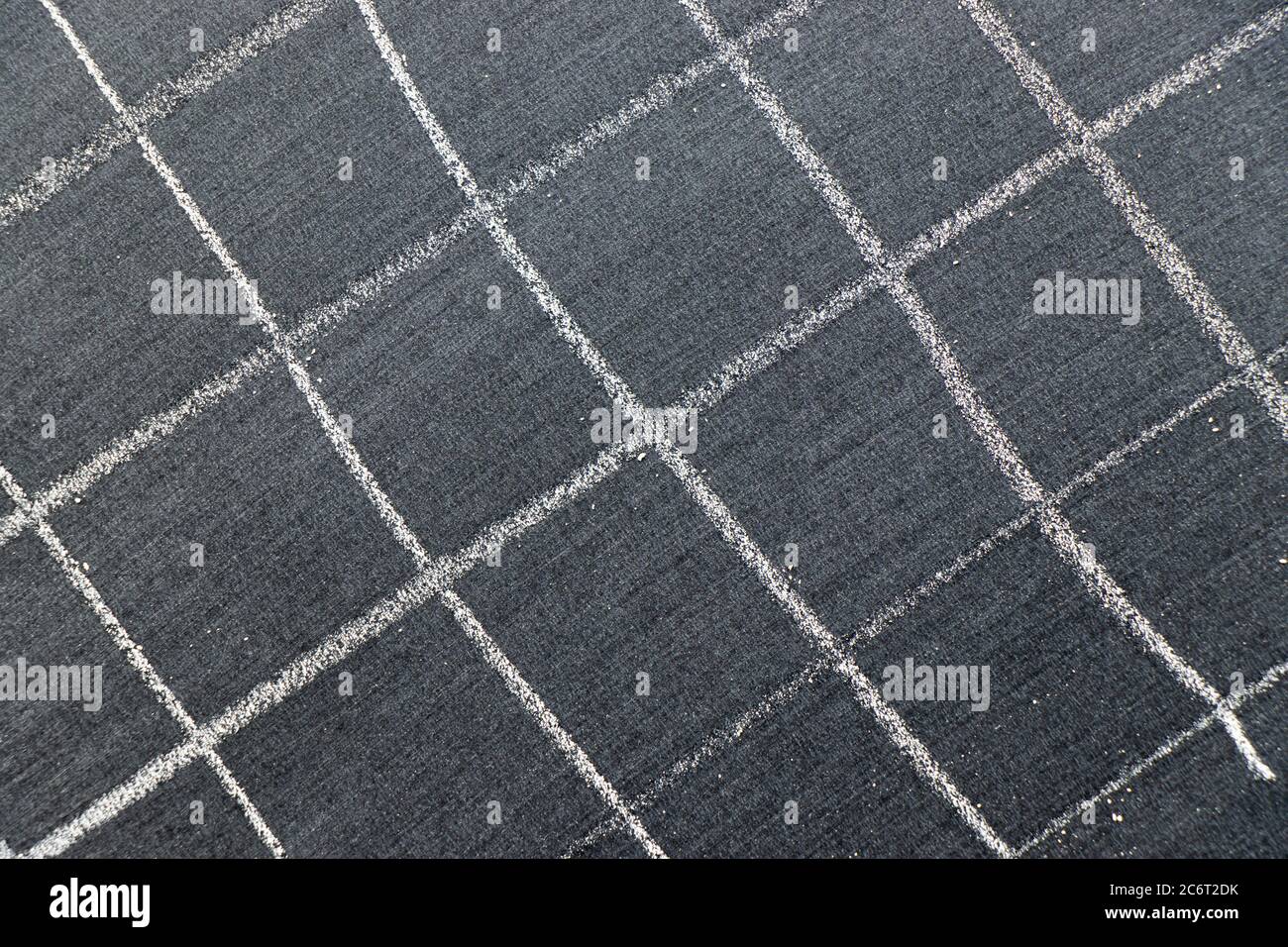 White color chalk hand drawing in check pattern shape on black board ...