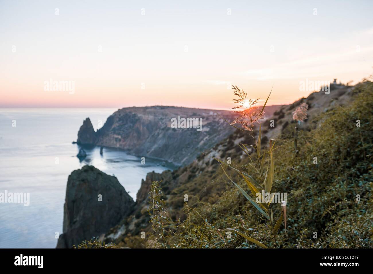 Autumn sea landscape with warm sunset light over rocky coastline. Calm ...