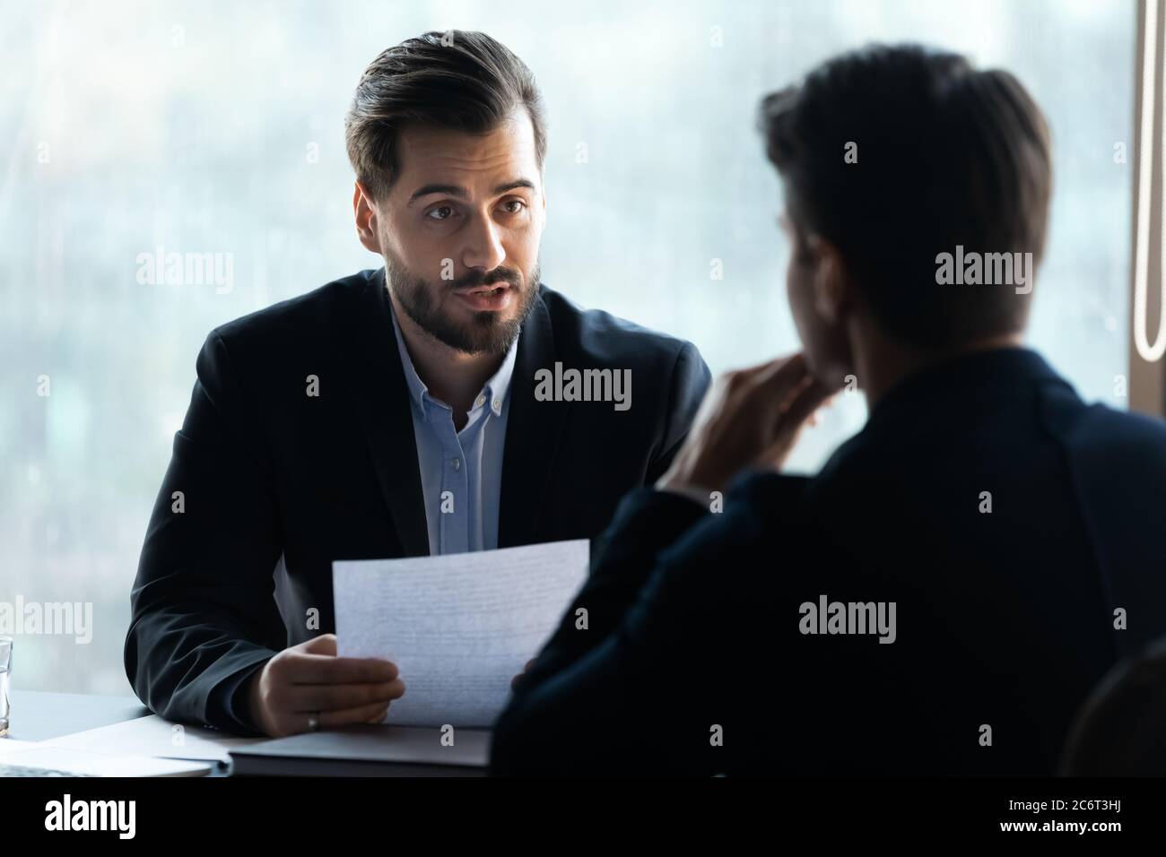 Serious young businessman holding job interview with applicant Stock ...