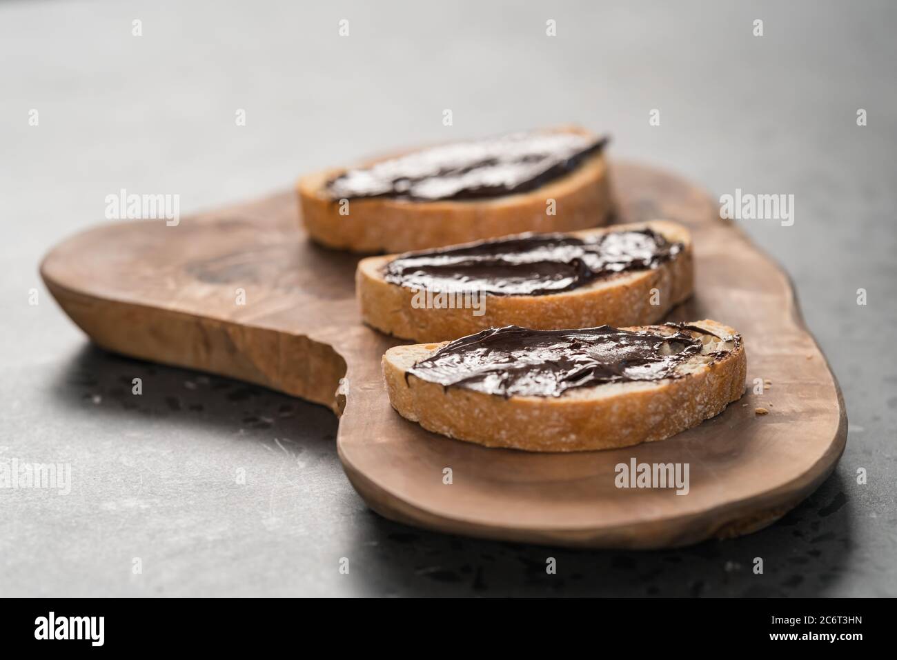 Rustic ciabatta with organic chocolate cream on olive wood board Stock ...