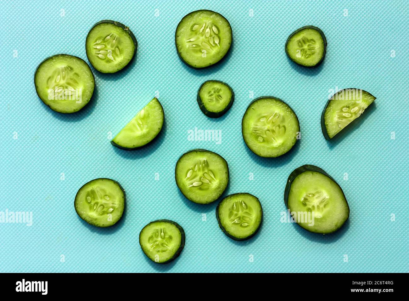 Cucumber creative layout. Slices of fresh cucumbers on turquoise ...