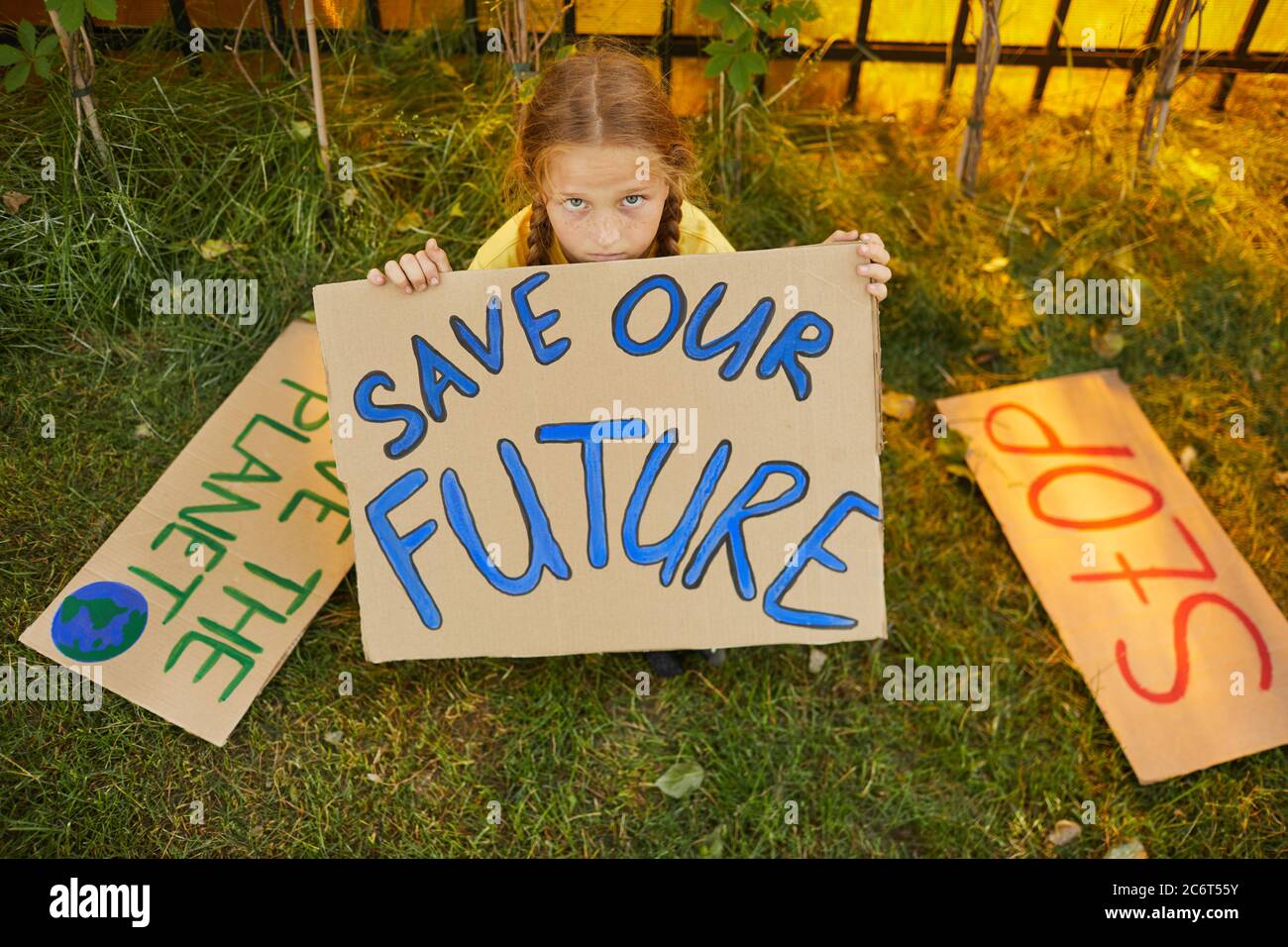 High angle portrait of freckled girl holding SAVE OUR FUTURE sign and ...