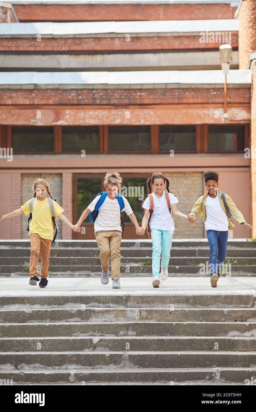 Bonding childhood leaving school building holding hands hi-res stock ...