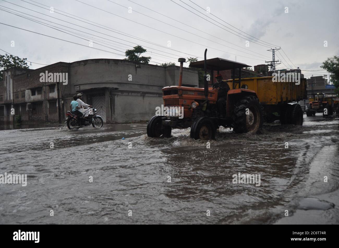 Peshawar, Pakistan. 12th July, 2020. People crossing a rain water at ...