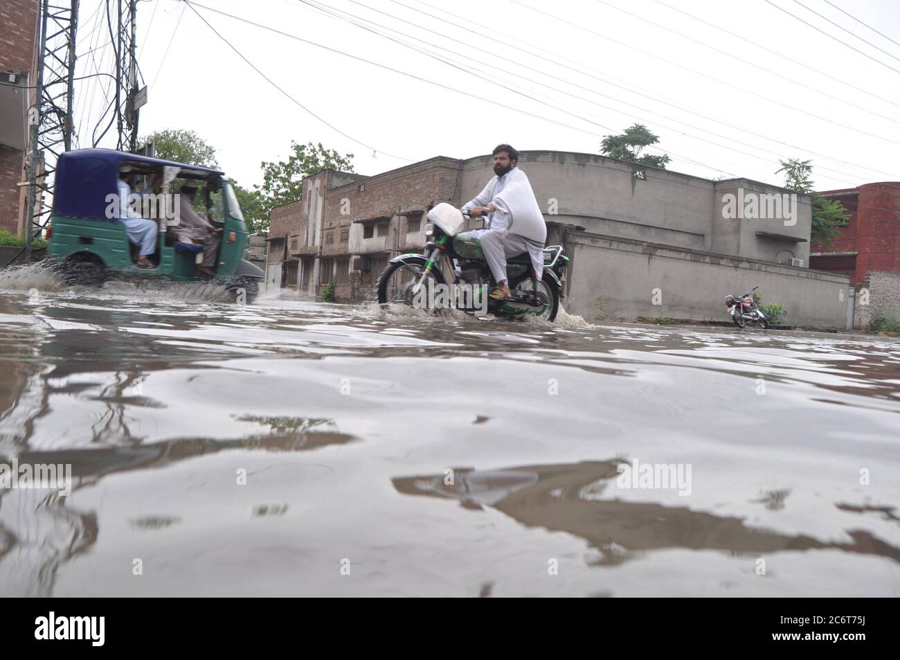 Peshawar, Pakistan. 12th July, 2020. People crossing a rain water at ...