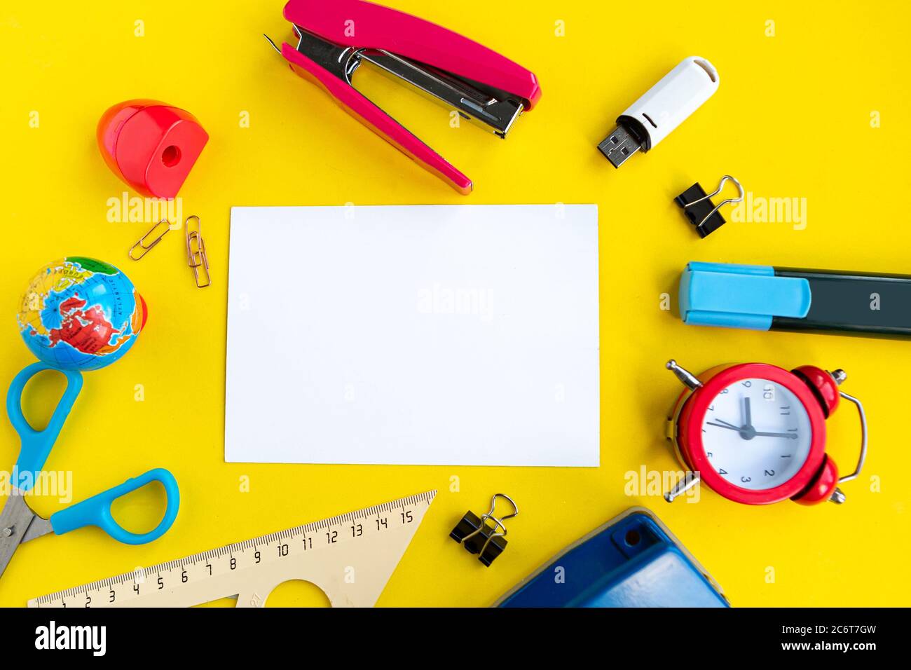 School supplies and white mockup blank on bright yellow background, top ...