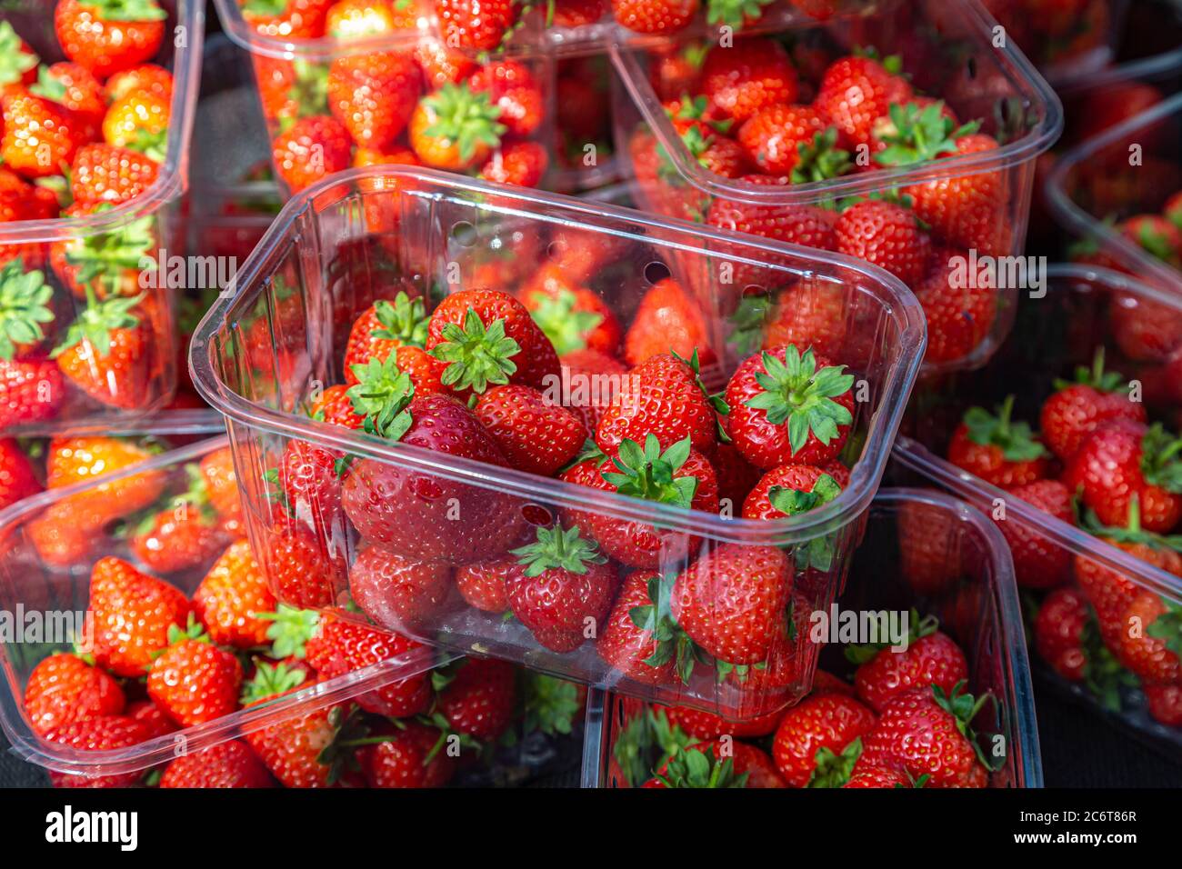 Plastic punnets of ripe strawberries for sale on a market stall Stock ...