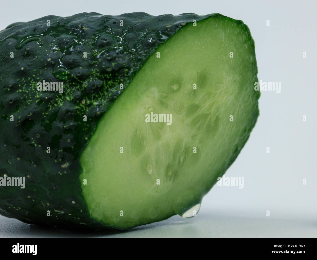 Green wet cucumber half piece of vegetable, inside macro view, white ...
