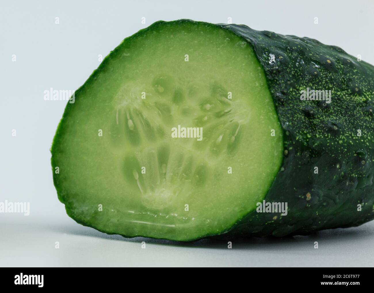 Green wet cucumber half piece of vegetable, inside macro view, white ...