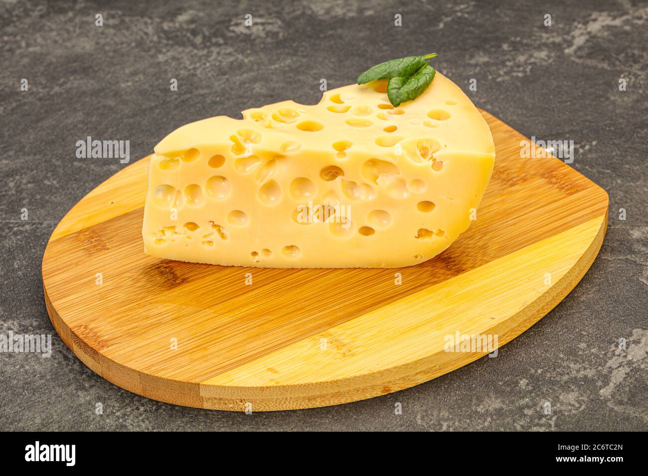 Maasdam cheese - dairy yellow triangle with holes Stock Photo - Alamy