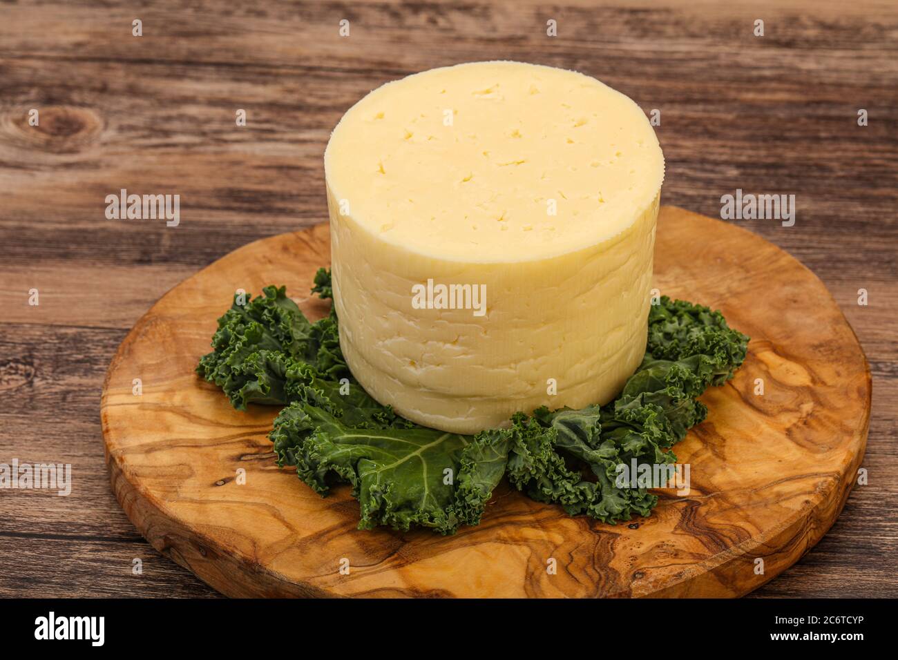 Yellow round dairy soft cheese piece Stock Photo - Alamy
