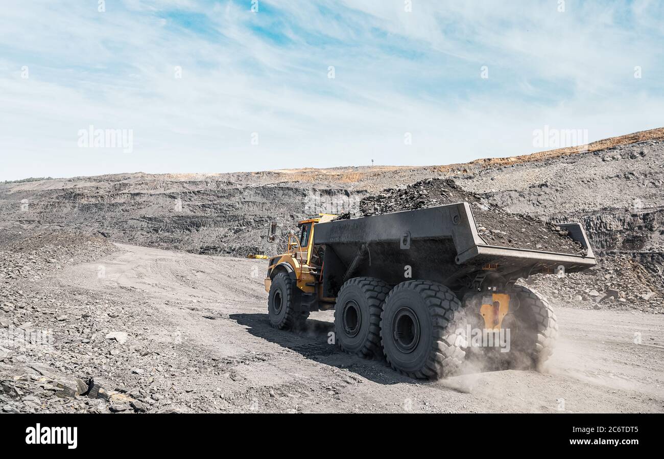 Large quarry dump truck. Loading the rock in dumper. Loading coal into body truck. Production ...