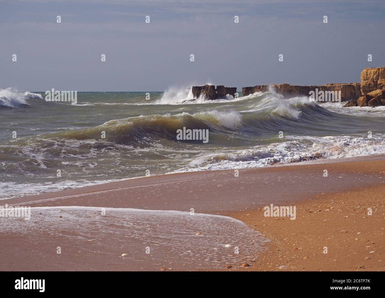 rough sea sand beach with beautiful sandstone cliffs and big waves ...