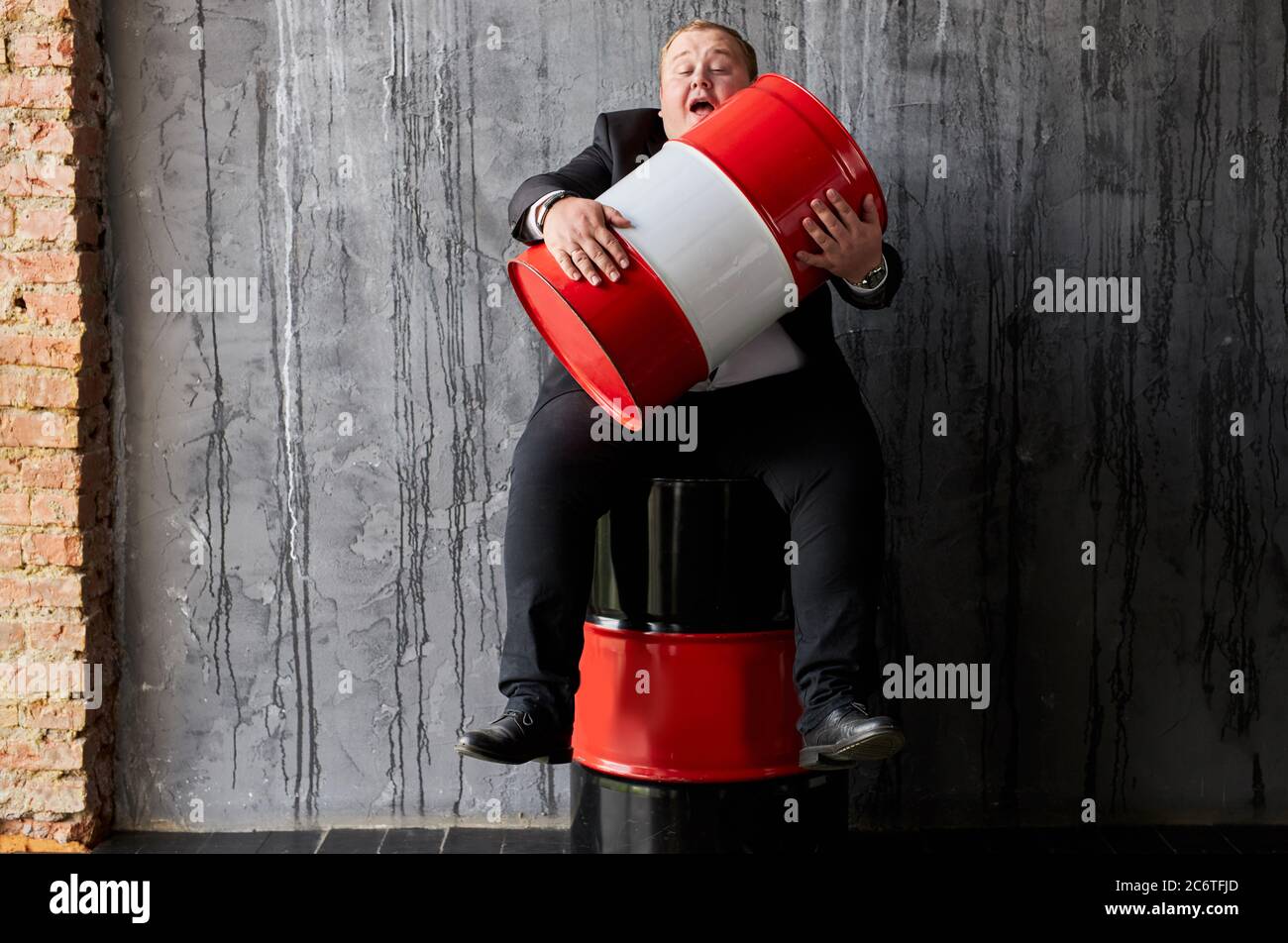 greedy caucasian fat oil tycoon hugs oil barrel. handsome businessman ...