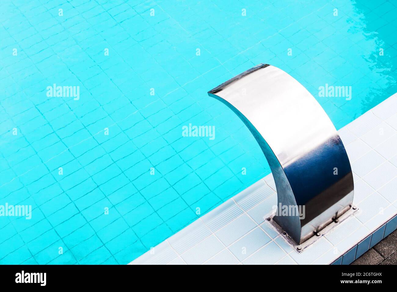 Blue swimming pool with a modern stainless steel water flowon massage ...