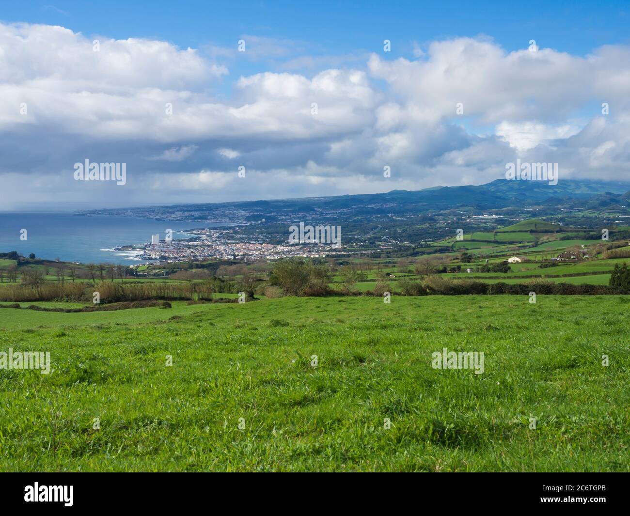 view on Lagoa city ocean bay with lush green grass hills, fields and ...