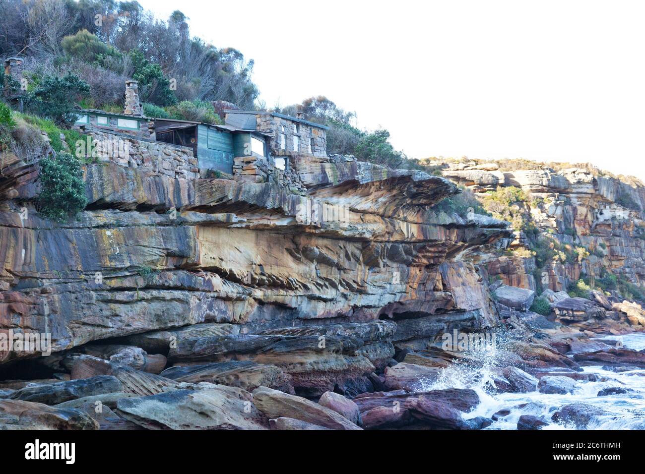 Historic old clifftop huts at an isolated cove in the National Park ...