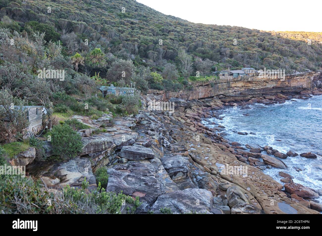 Historic old clifftop huts at an isolated cove in National Park ...