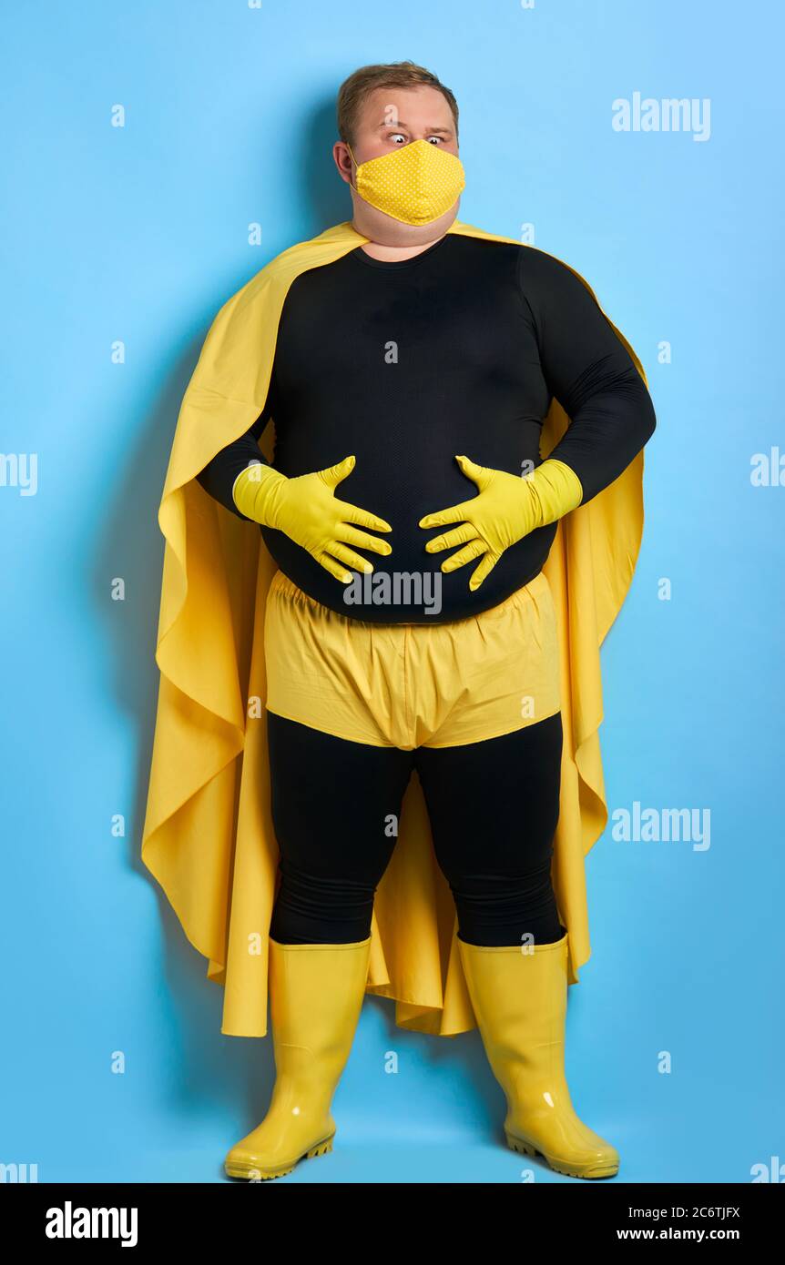 shocked fat guy touching his stomach isolated over blue background ...