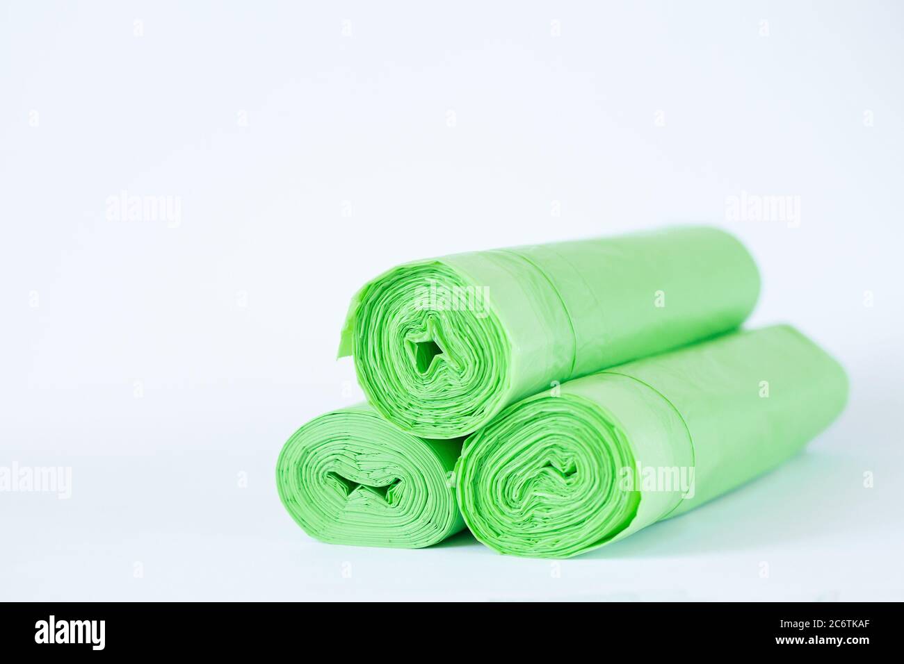 Three rolls of biodegradable eco plastic green bags isolated on white ...