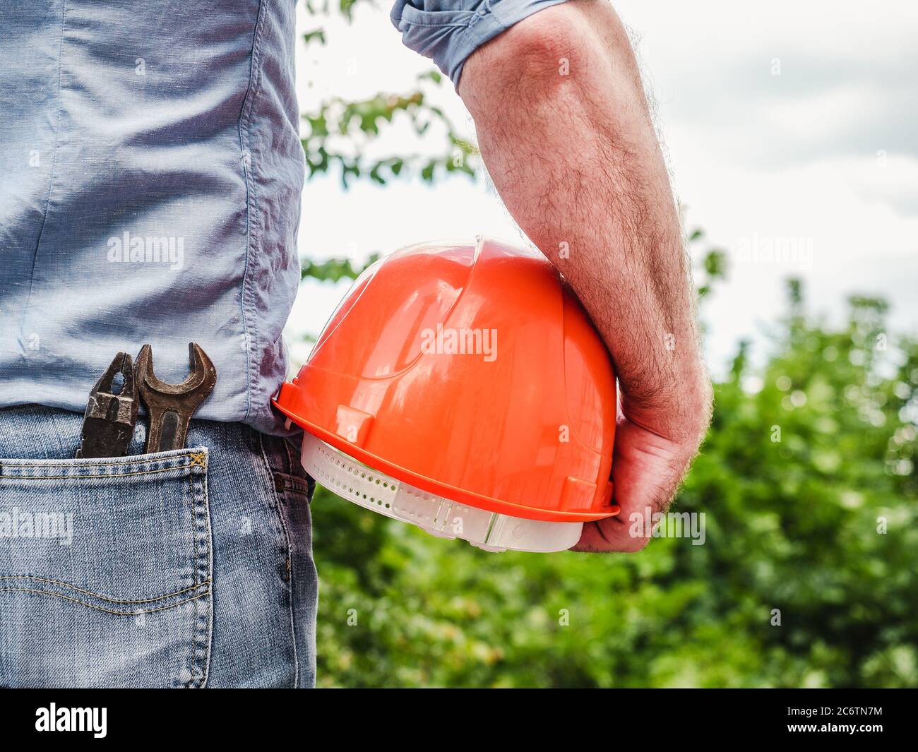 Man with tools holding a safety helmet Stock Photo - Alamy