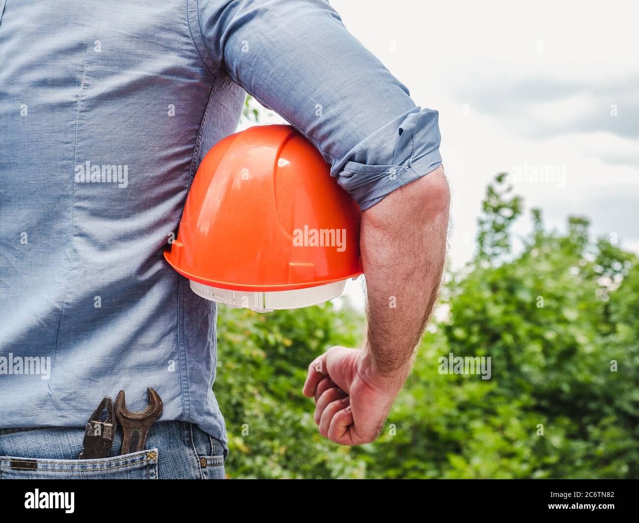 Man with tools holding a safety helmet Stock Photo - Alamy