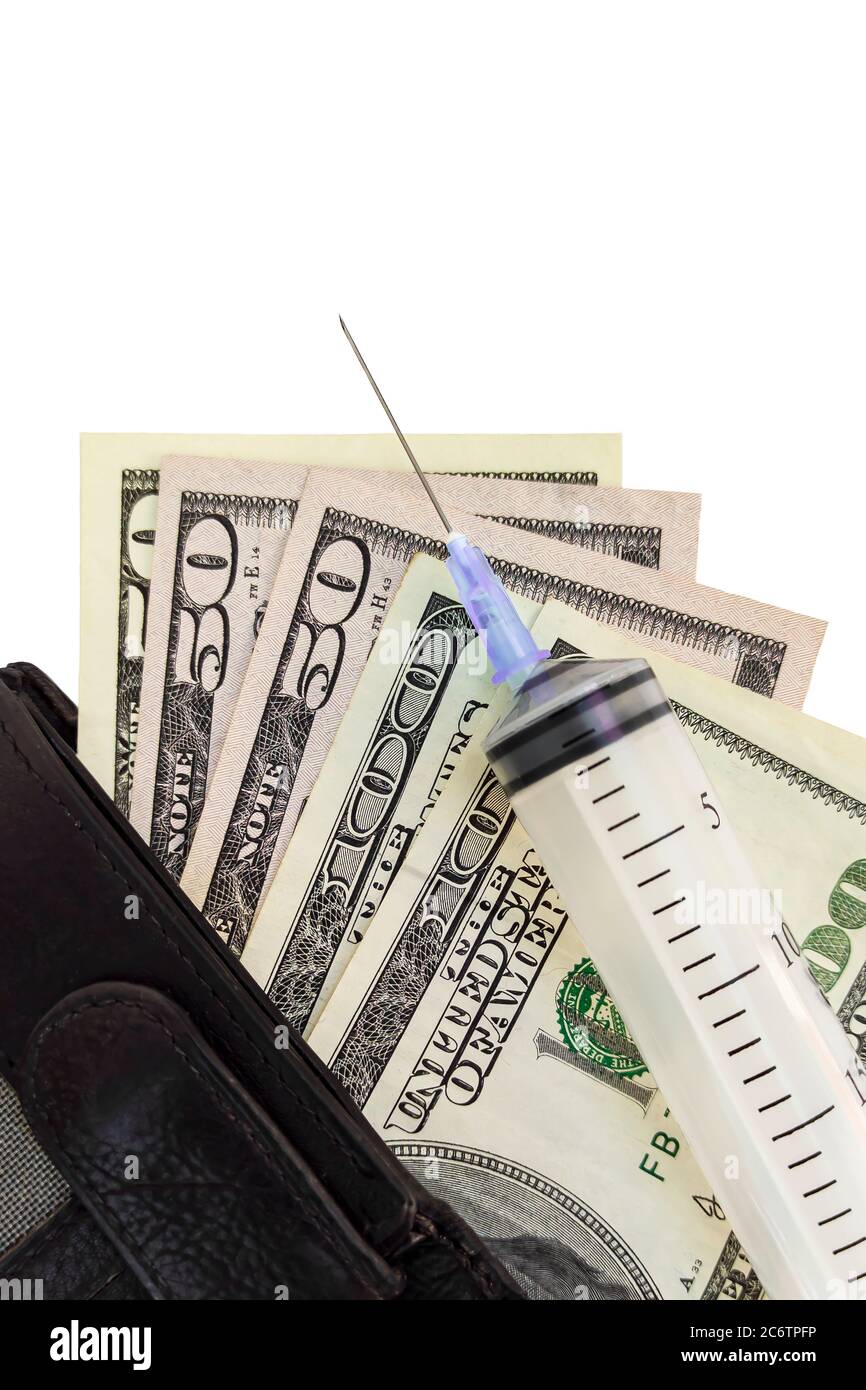 money peeks out of a purse and a syringe with an open needle lies on ...