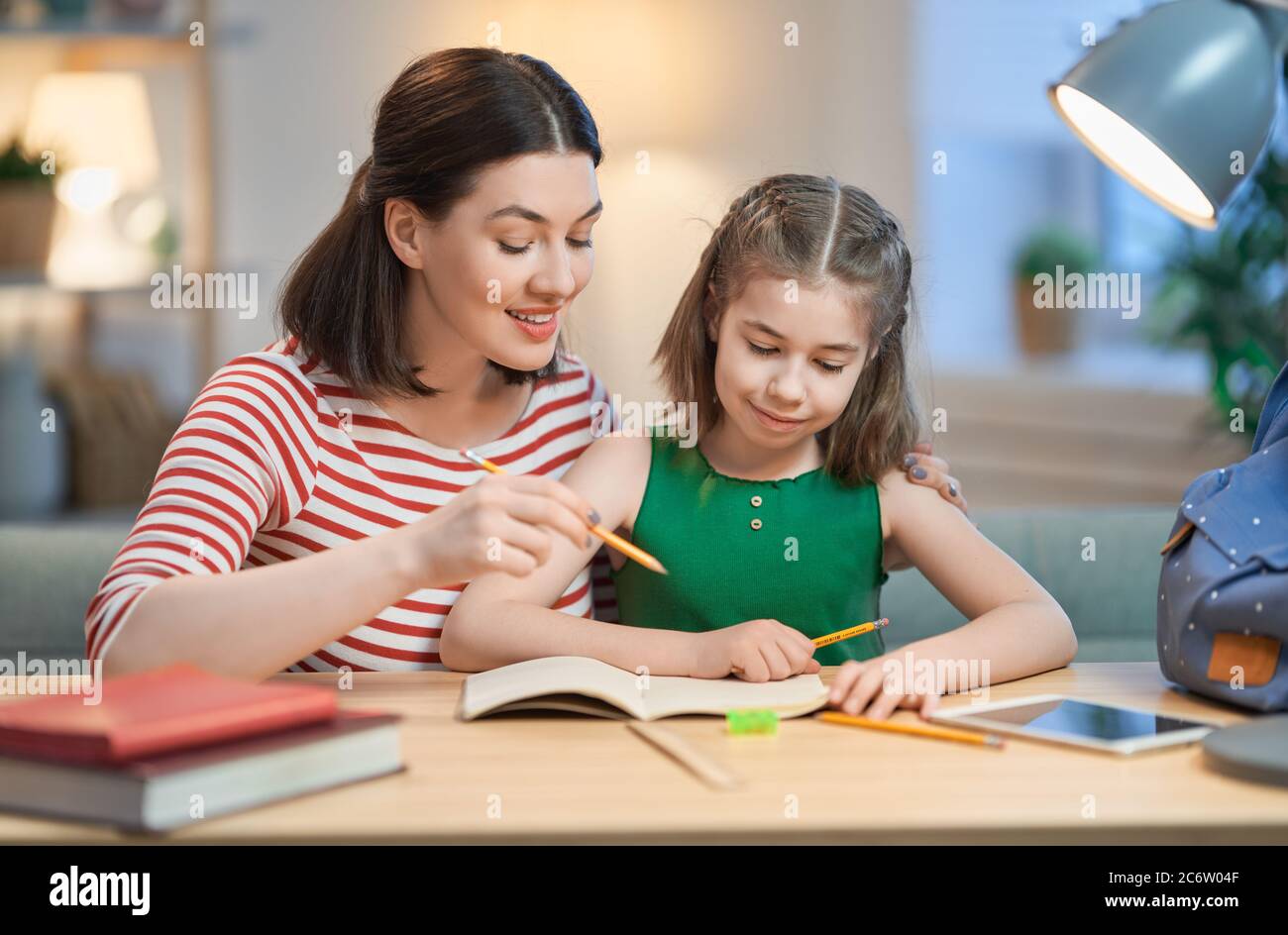 Back to school. Happy child is sitting at desk. Girl doing homework ...