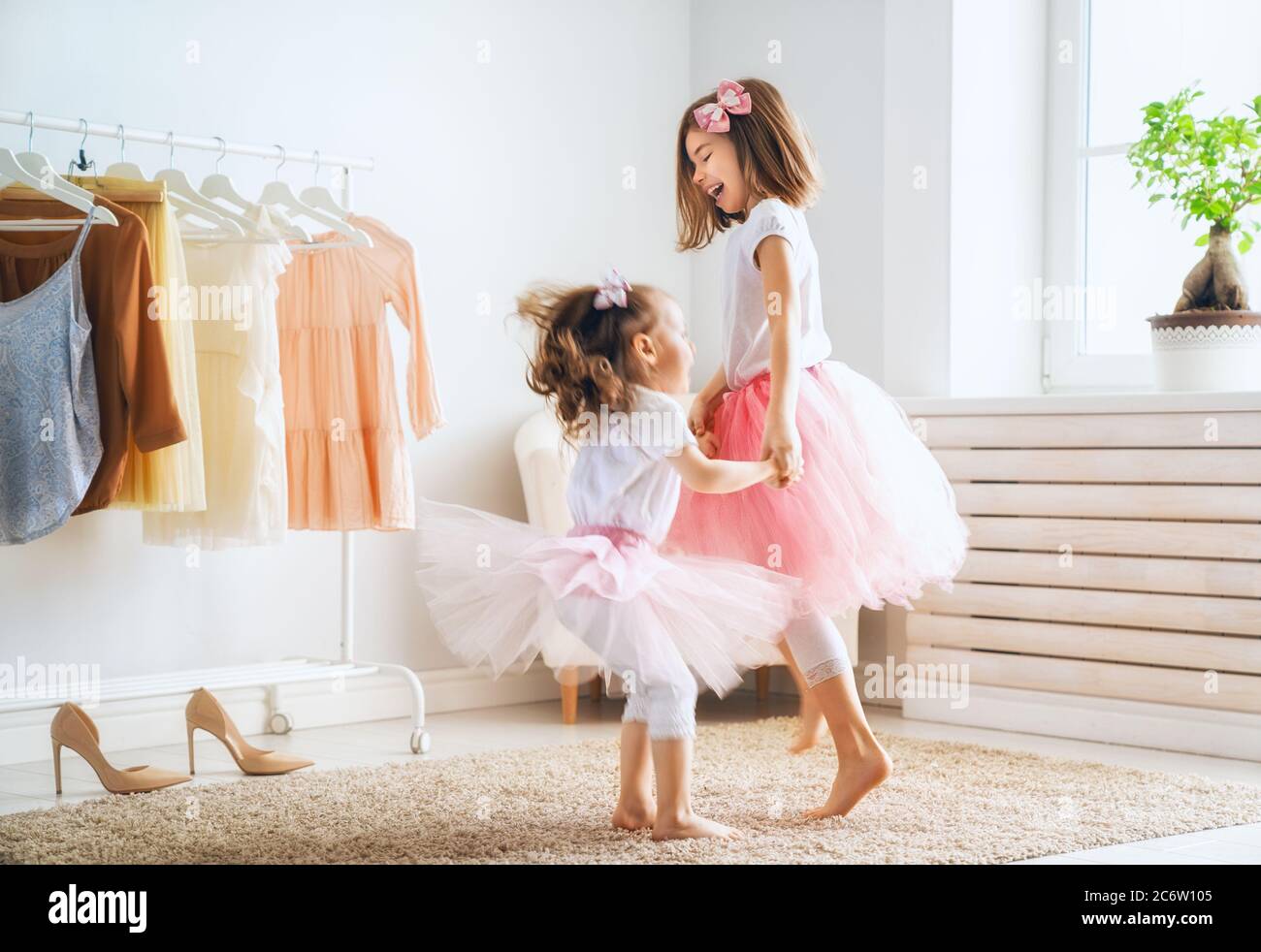 Happy girls dressing up at home. Funny lovely children are having fun ...