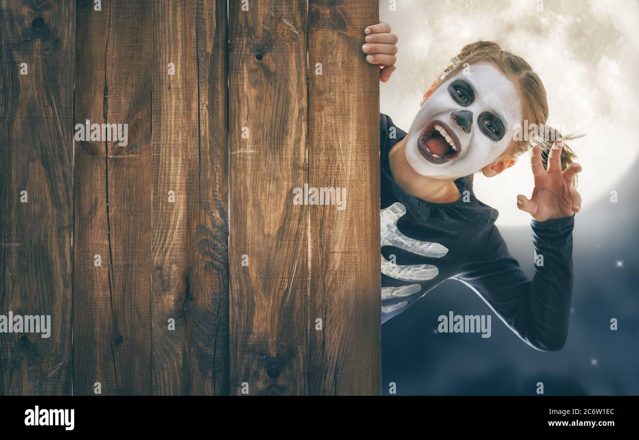 Happy Halloween! Cute little skeleton with pumpkin. Beautiful young ...