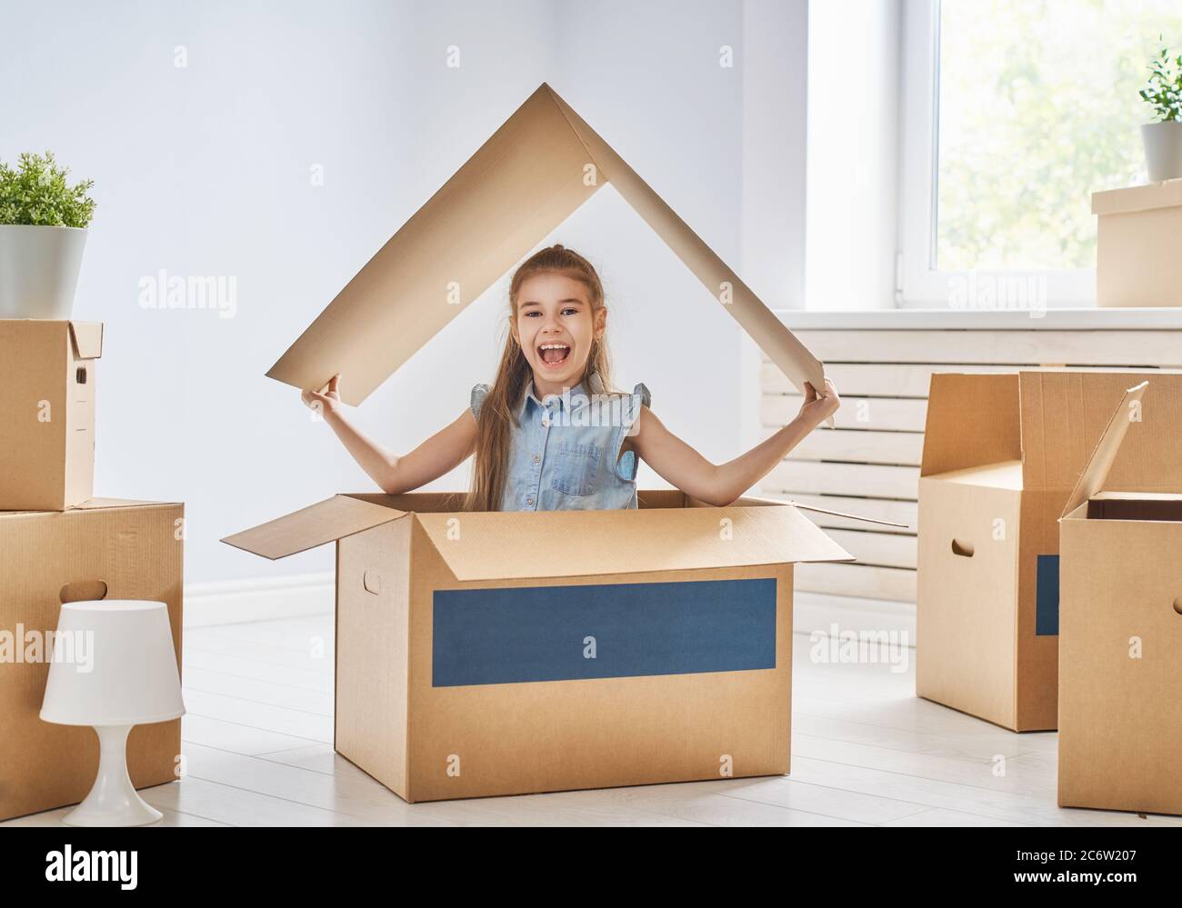 Child girl in the house with a symbol of roof. Concept of housing for ...