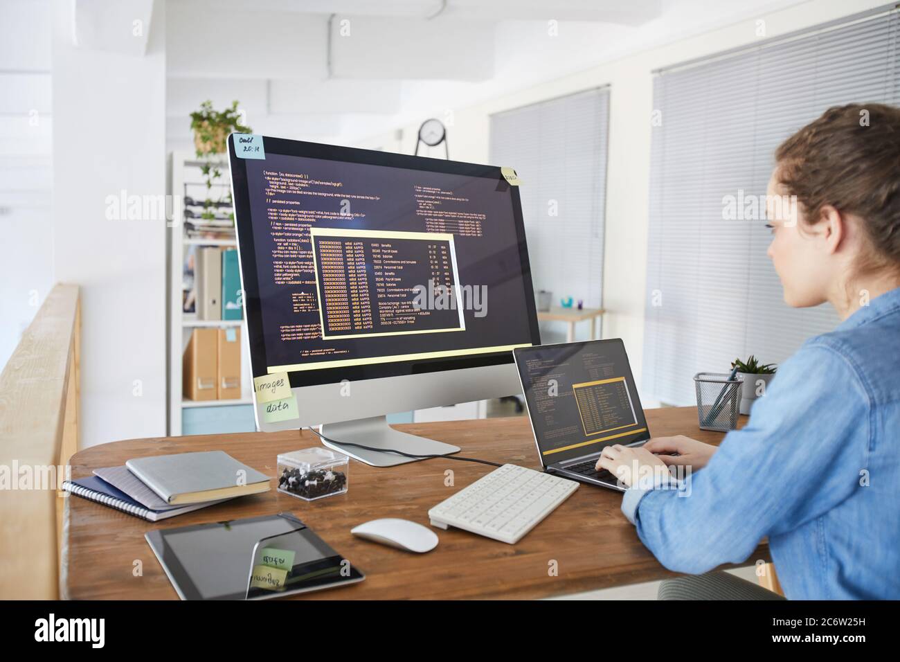 Portrait of female IT developer typing on keyboard with black and ...