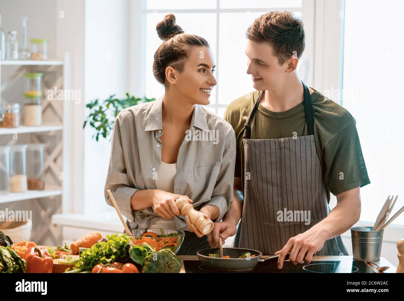 Healthy food at home. Happy loving couple is preparing the proper meal ...