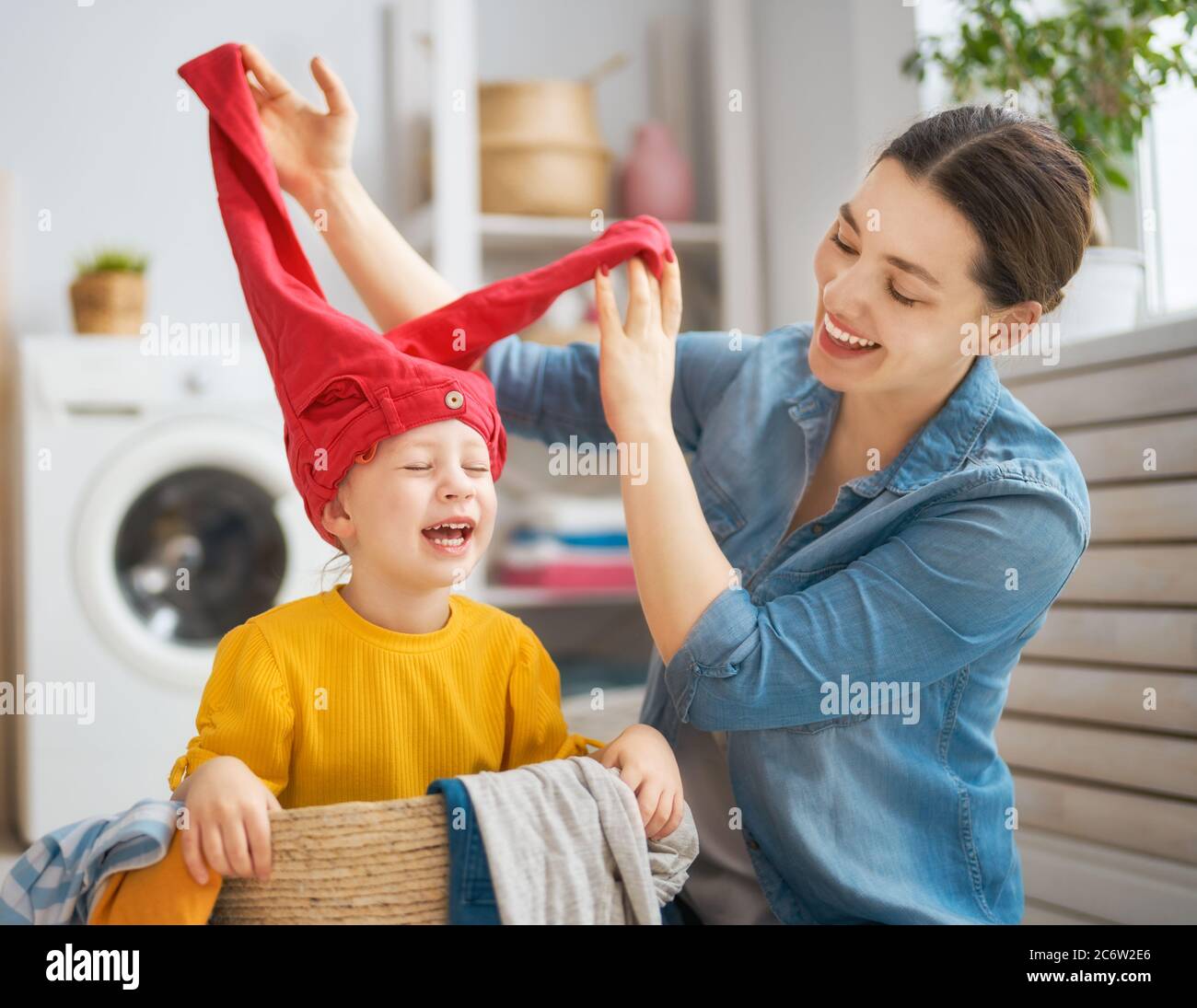 Beautiful young woman and child girl little helper are having fun and ...