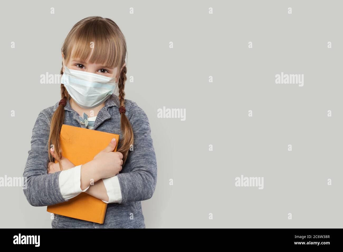 Happy child girl wearing medical protective face mask on white ...