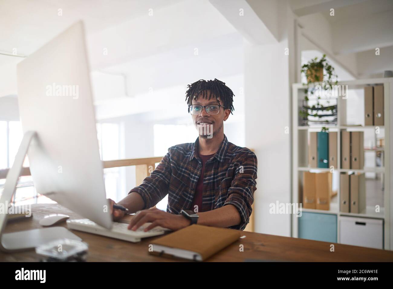 Portrait of contemporary African-American man smiling at camera while ...