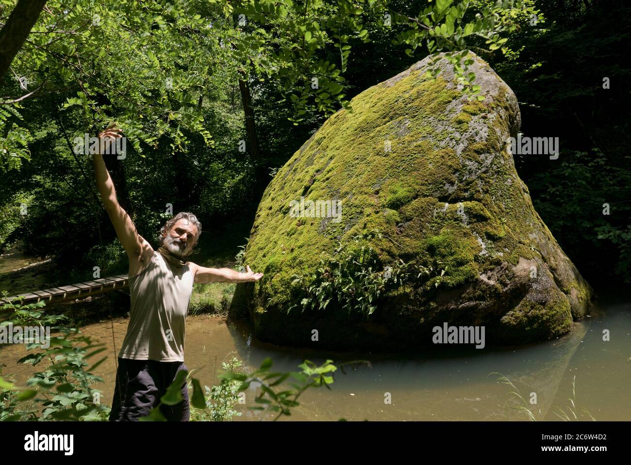 Man visiting an ancient sacred place with glacial hera giant erratic ...