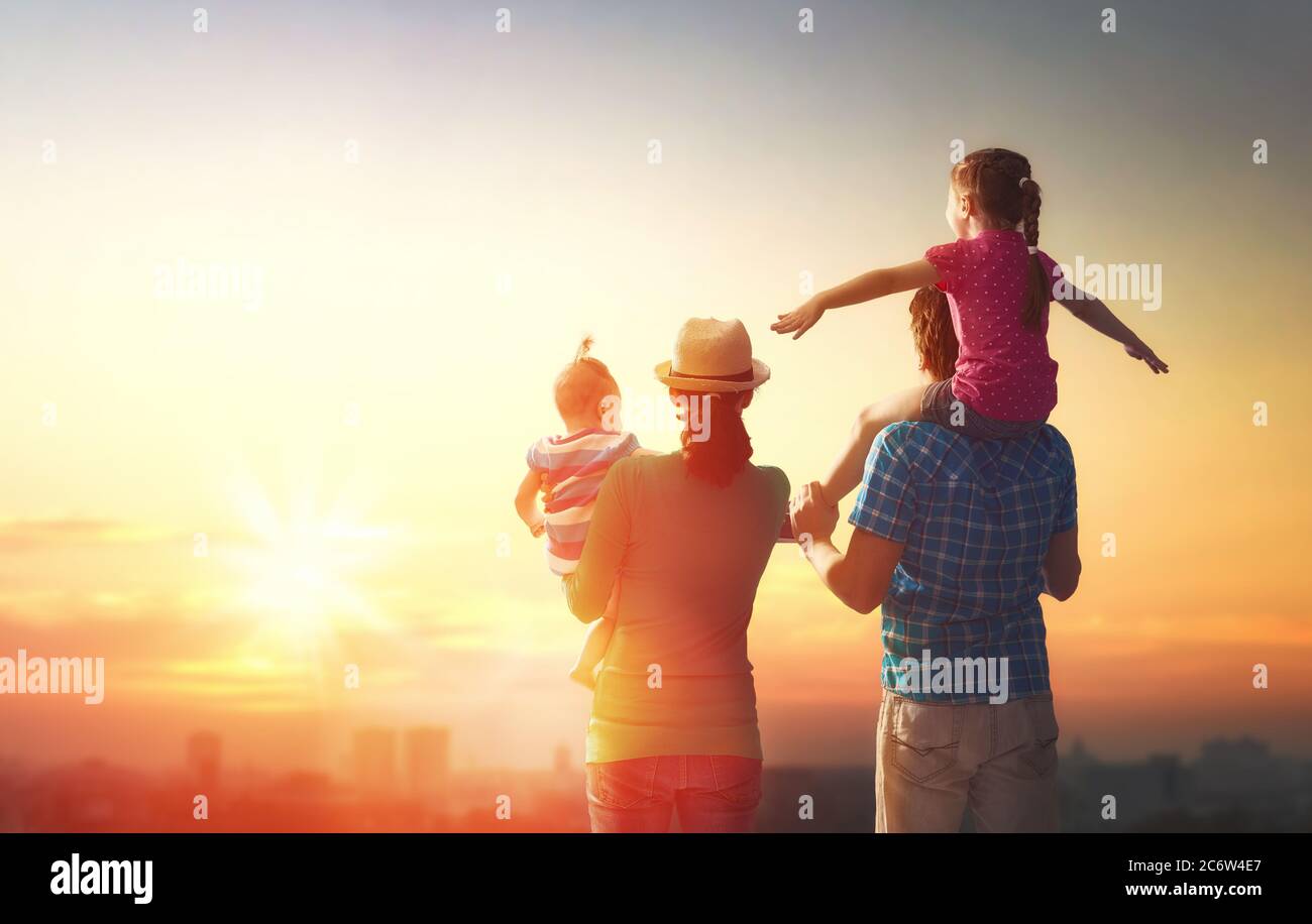 happy family at sunset. father, mother and two children daughters ...
