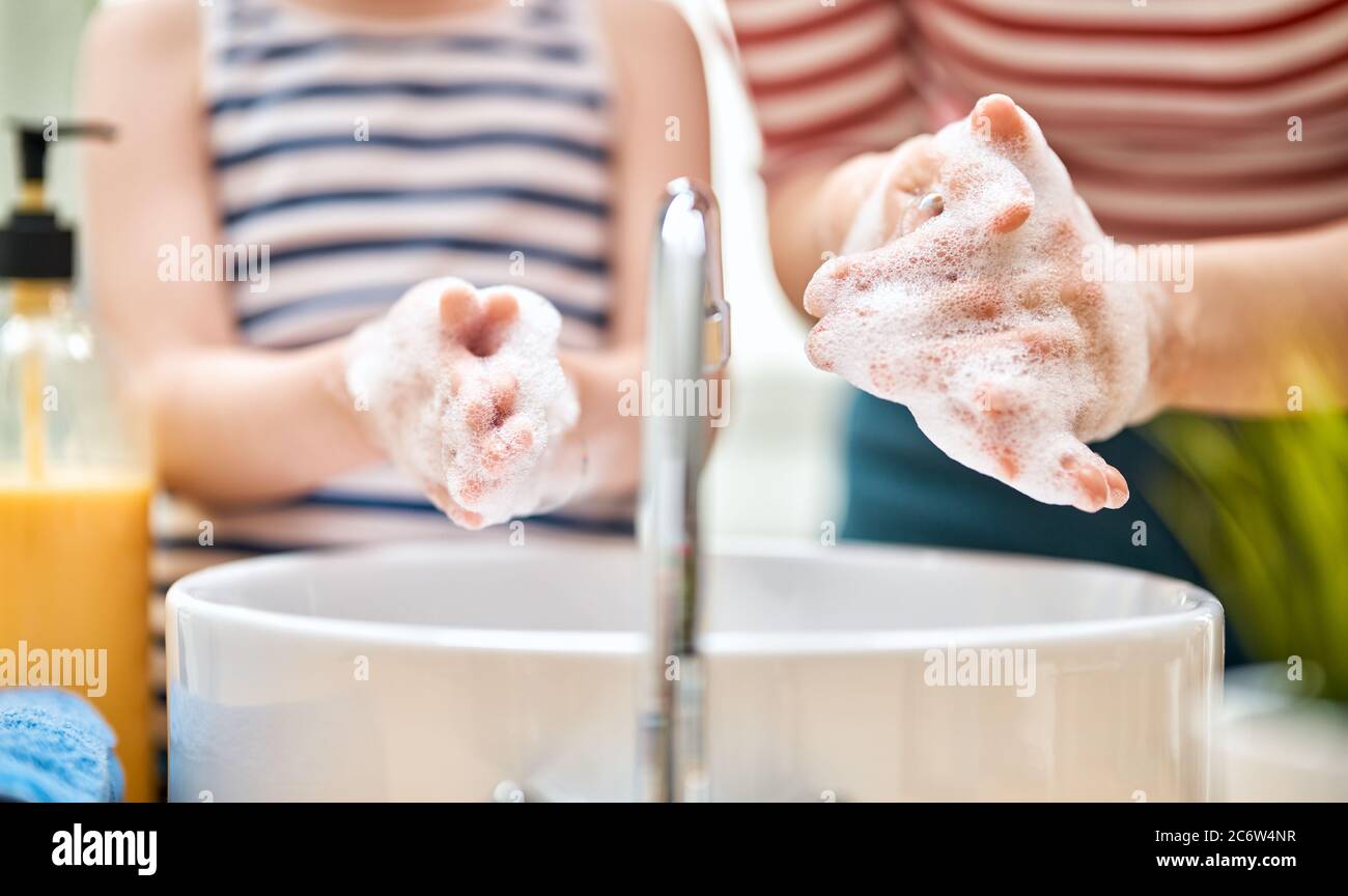 Kid and adult are washing their hands. Protection against infections ...