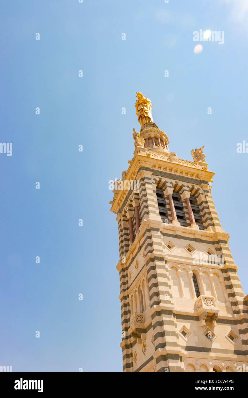 gold statue atop tower at Basilique Notre-Dame de la Garde In Marseille ...