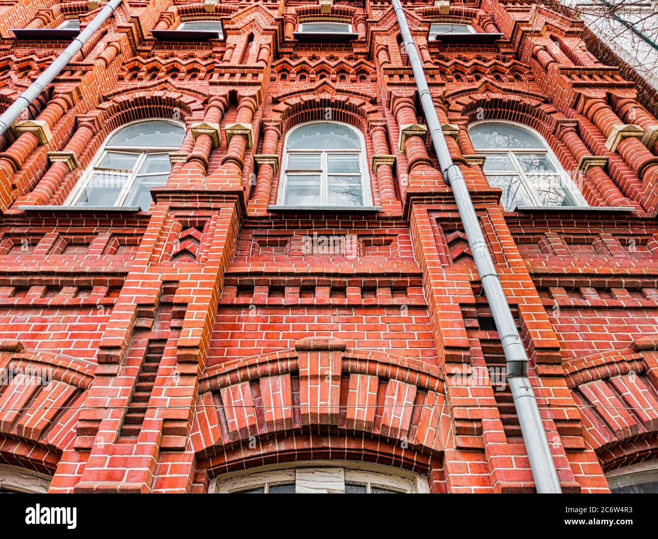 A look from below at the red brick building with tin drainpipes Stock ...