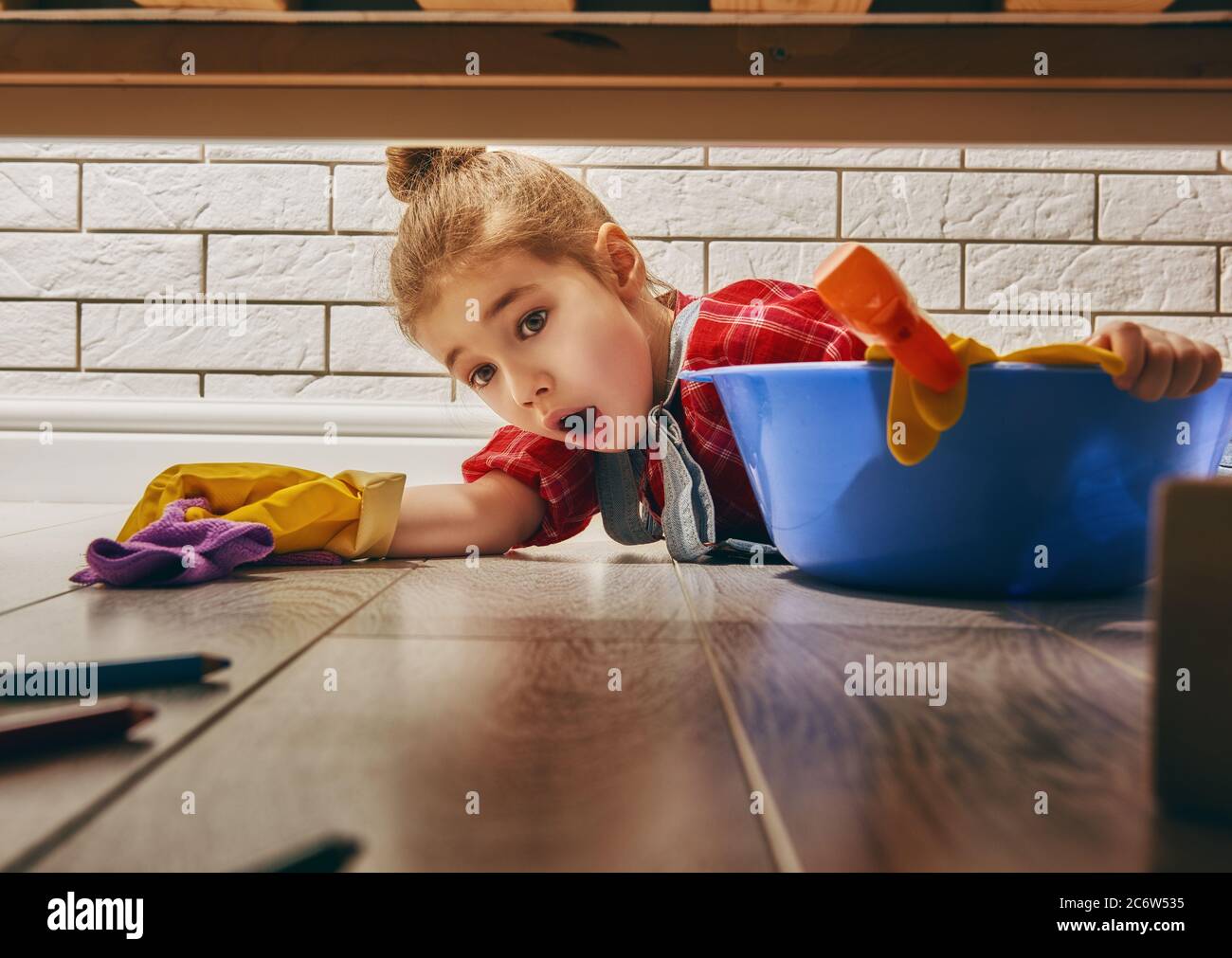 Charming little helper. Cute little child girl makes cleaning the house ...