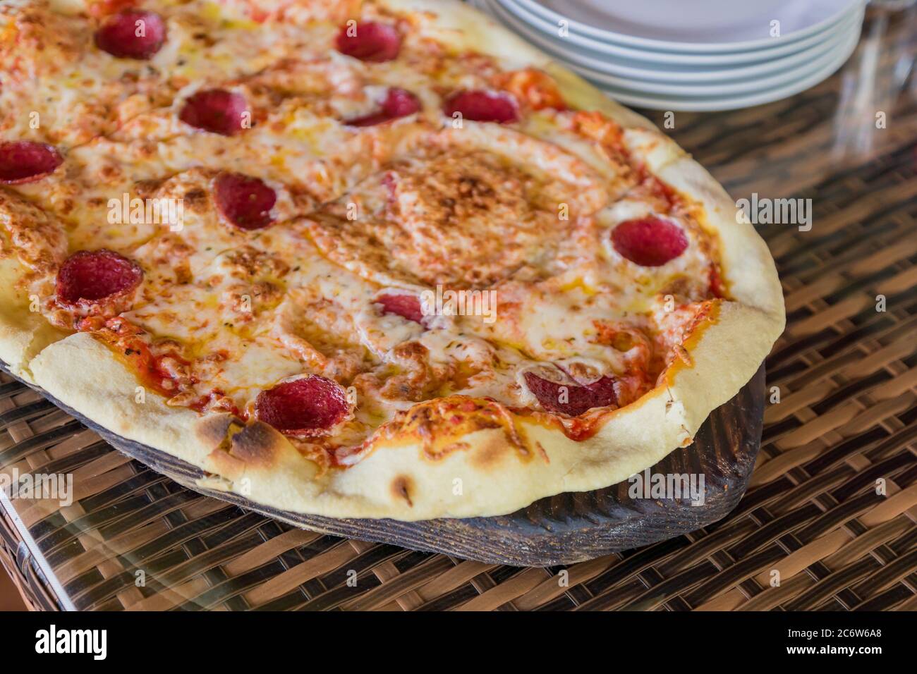 close up of pepperoni pizza on wooden desk Stock Photo - Alamy