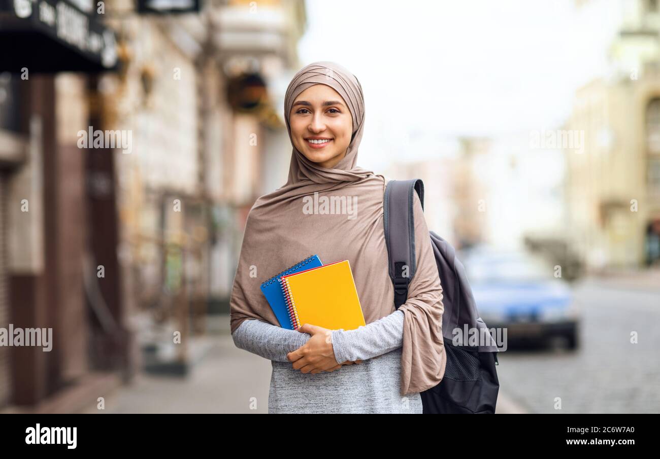 Muslim girl going to university, holding notepads Stock Photo - Alamy
