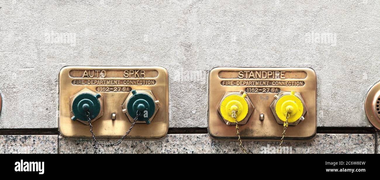 Two wall mounted brass standpipes with green and yellow caps. New York ...