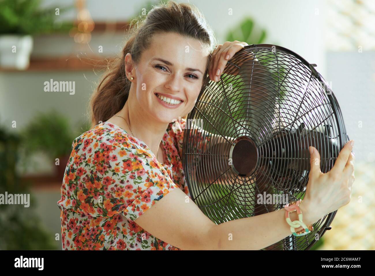 Summer heat. Portrait of happy modern female in floral blouse in the ...