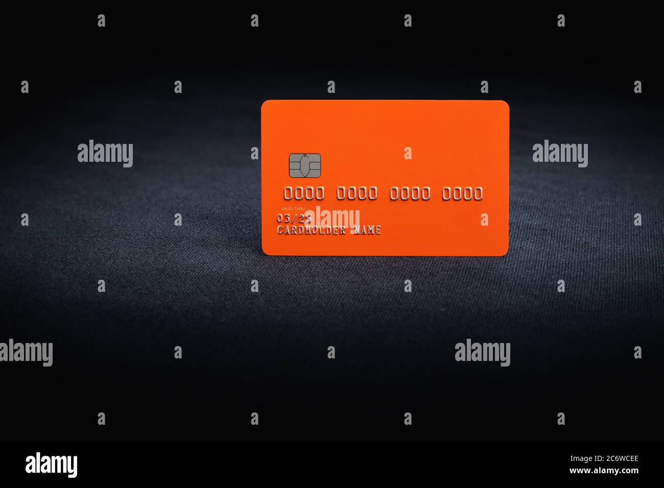 Orange credit card on dark textile background Stock Photo - Alamy