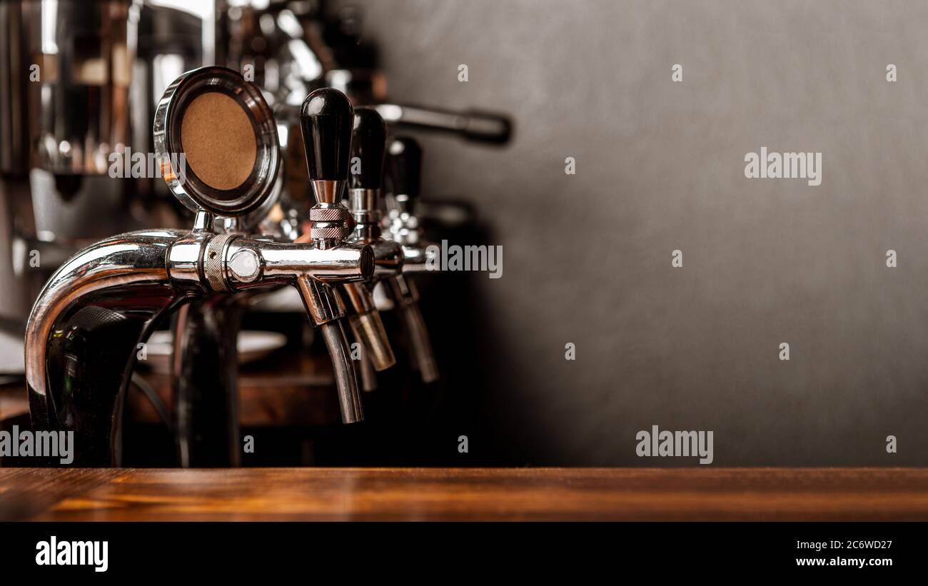 Modern pub. Metal taps for beer behind bar counter Stock Photo - Alamy
